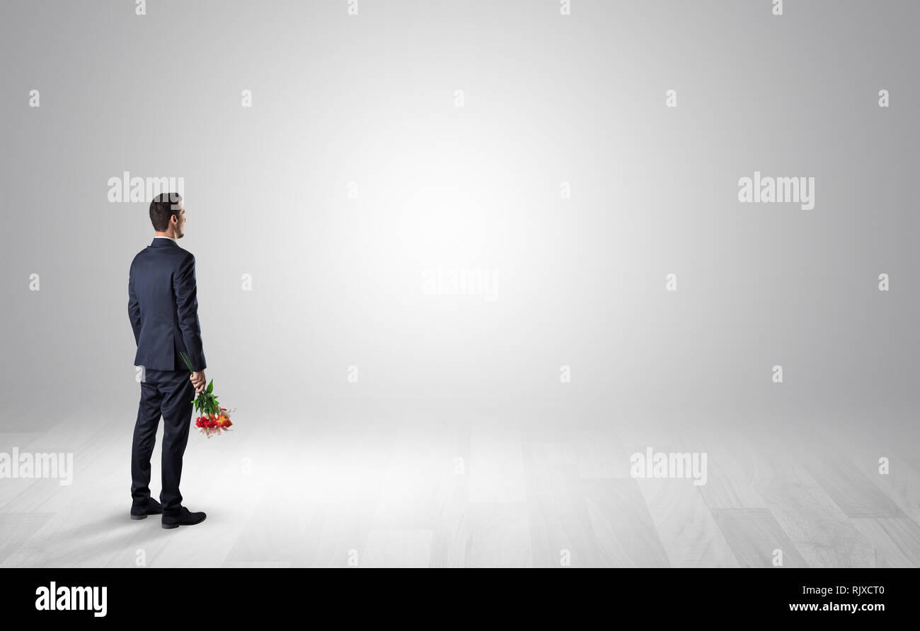 Man standing with his back in an empty room with object in his hand ...
