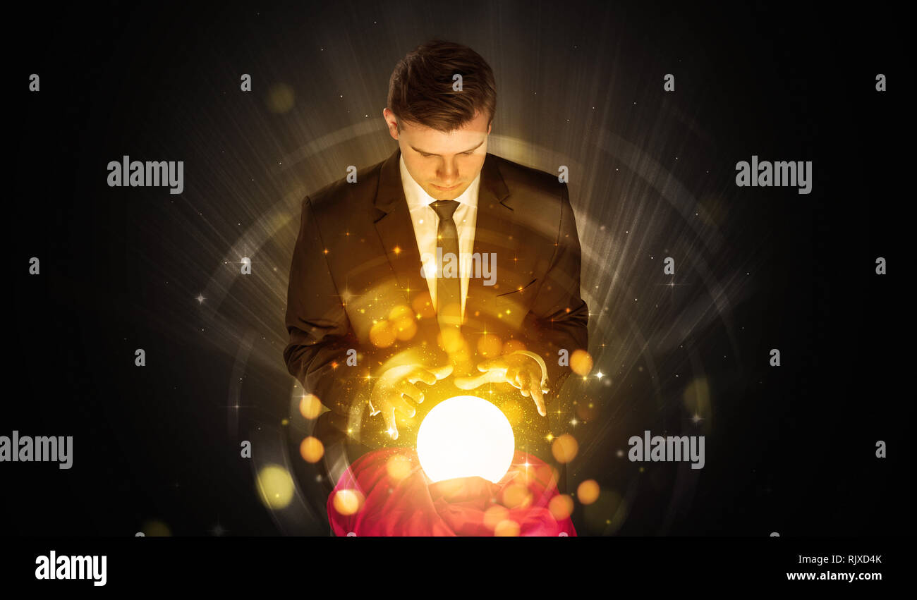 Gorgeous businessman sitting with sparkling magic ball in his lap Stock ...