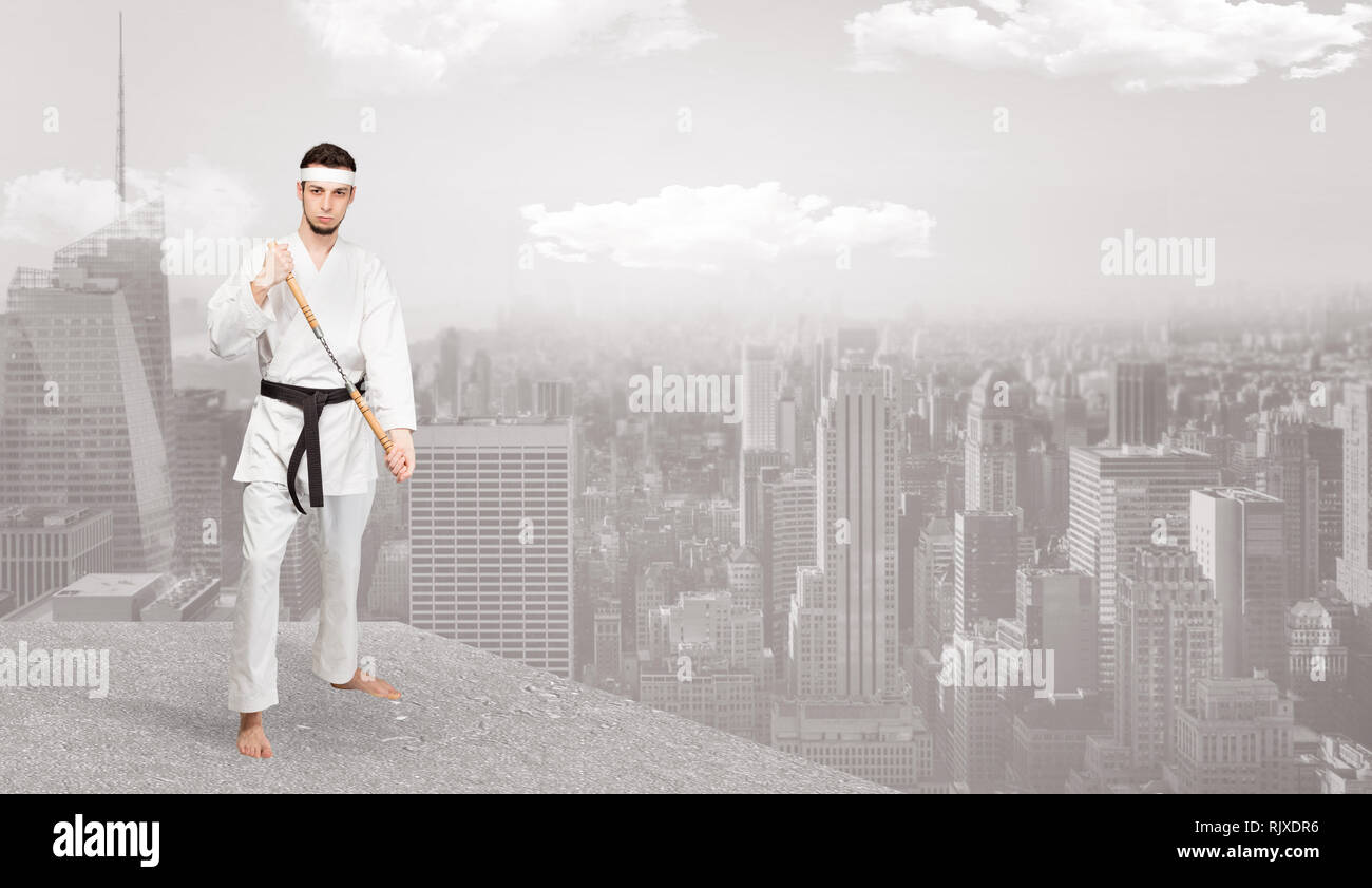 Young karate trainer doing karate tricks on the top of a metropolitan ...