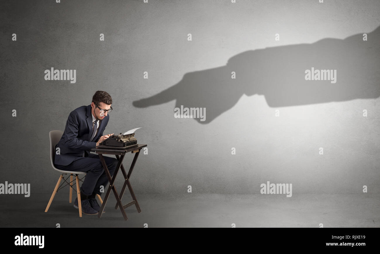 Shadow hand pointing at a small afraid worker Stock Photo - Alamy