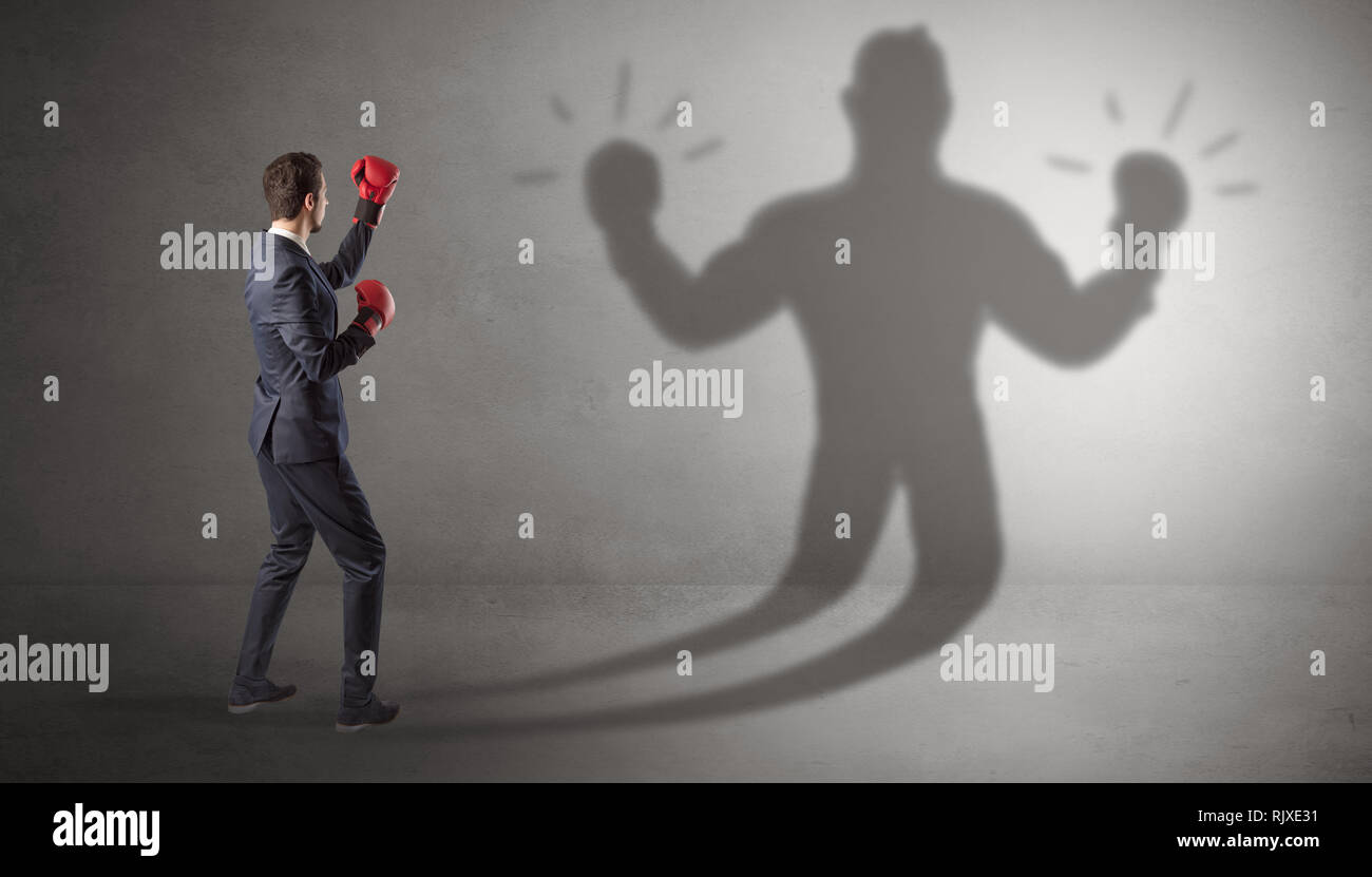 Businessman trying to fight with his unarmed shadow Stock Photo - Alamy
