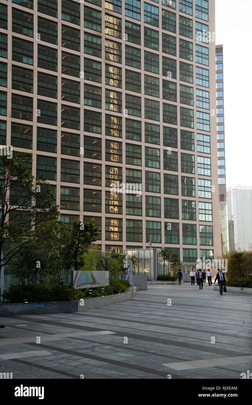 An elevated pedestrian walkway between modern skyscrapers in the Minato ...