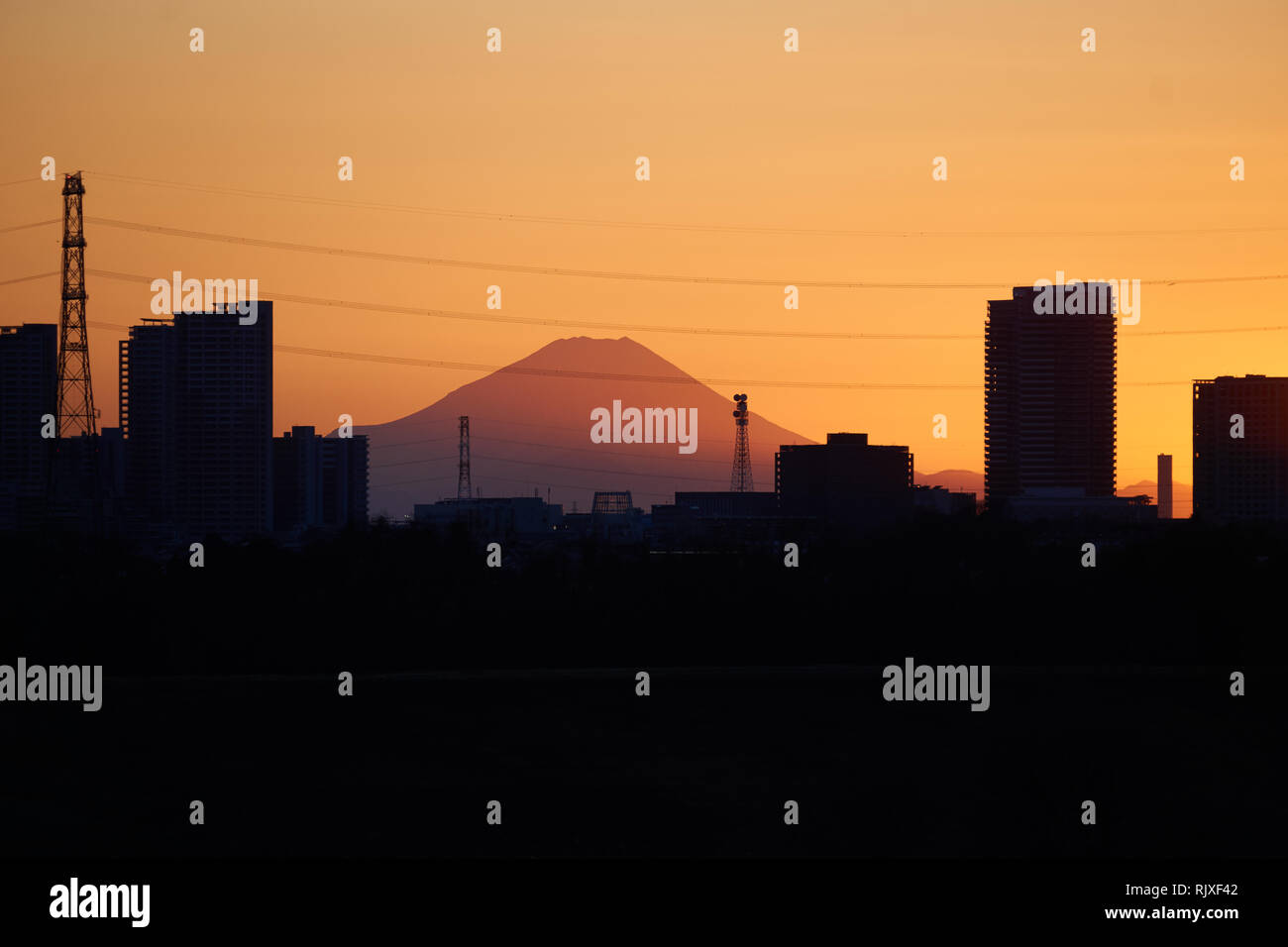 Mount Fuji in Japan at Sunset with skyscraper towers and power lines ...