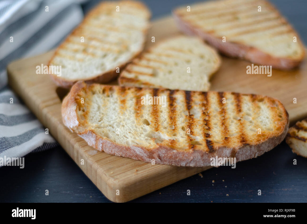 Slices of fresh toasted bread on wooden background Stock Photo - Alamy