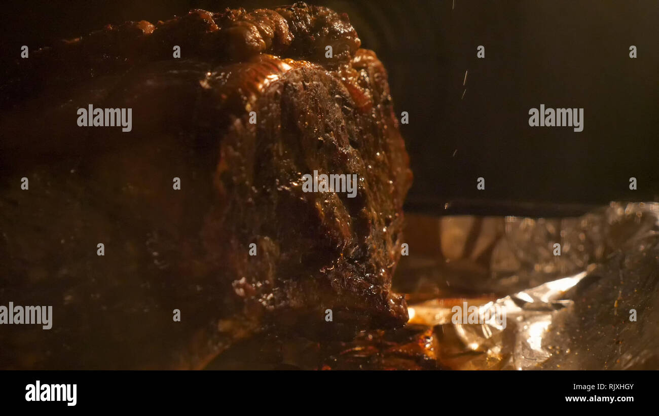 closeup view roasting beef joint on foil covered tray cooking inside ...