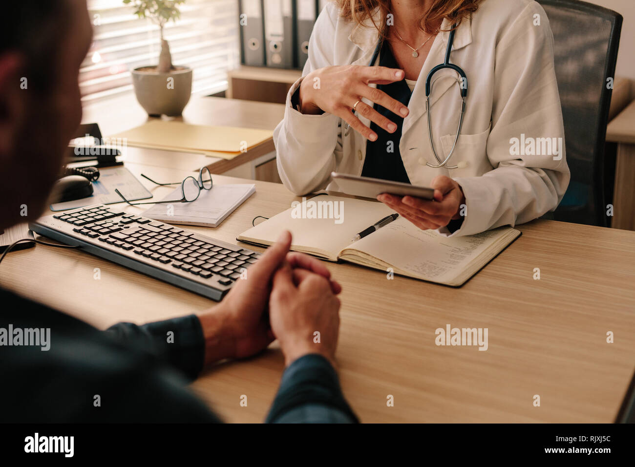 Female doctor talking about the treatment with male patient at her ...