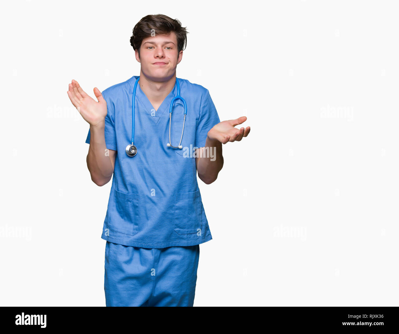 Young doctor wearing medical uniform over isolated background clueless ...