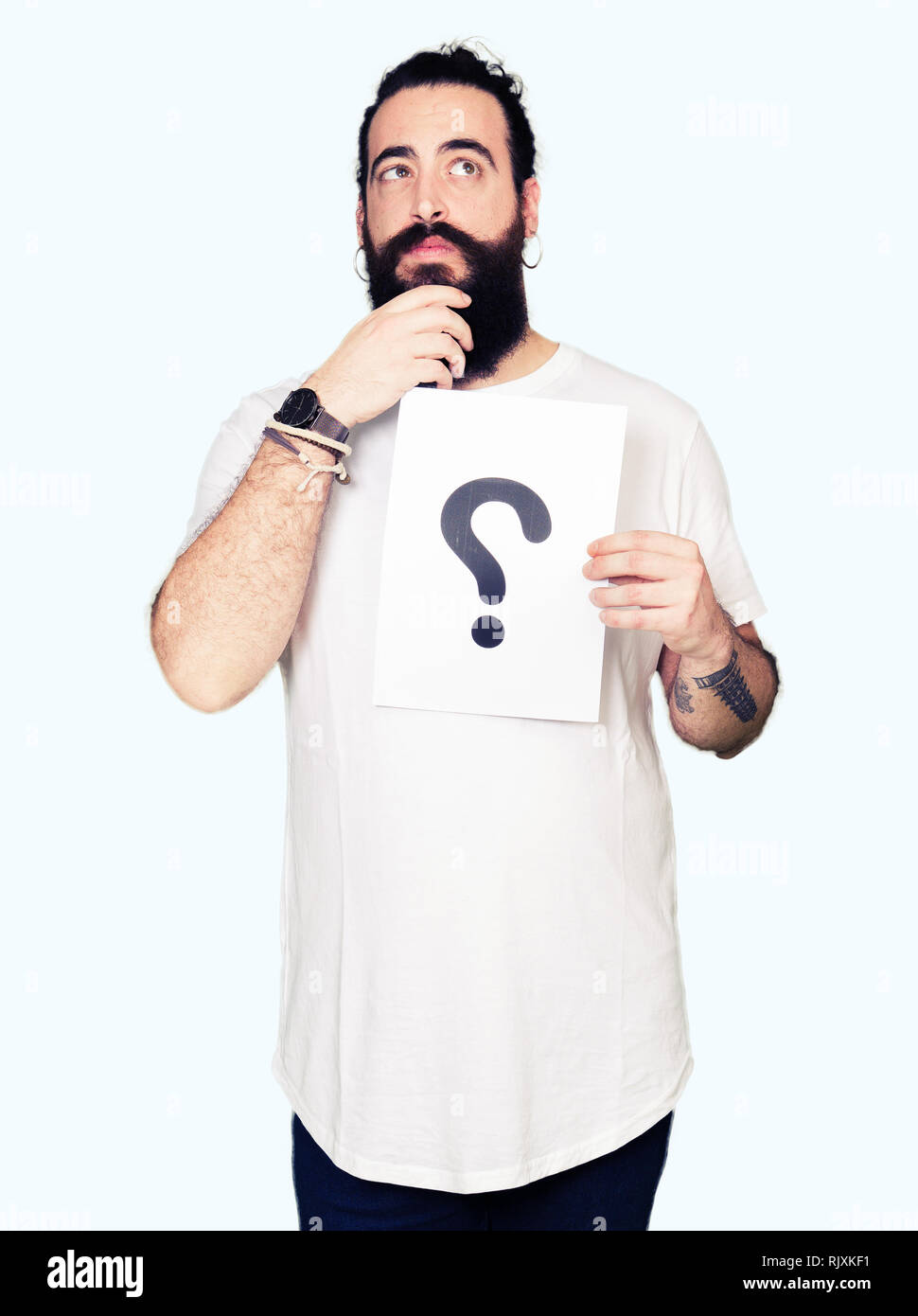 Young man with long hair and bear holding a paper with question mark ...