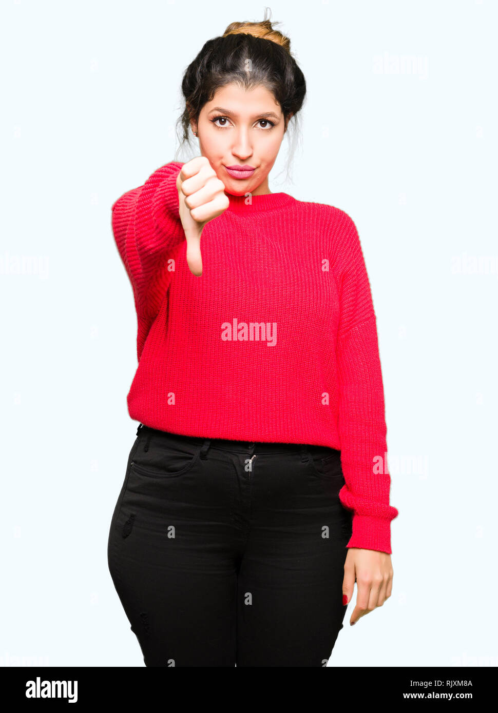 Young beautiful woman wearing red sweater and bun looking unhappy and ...