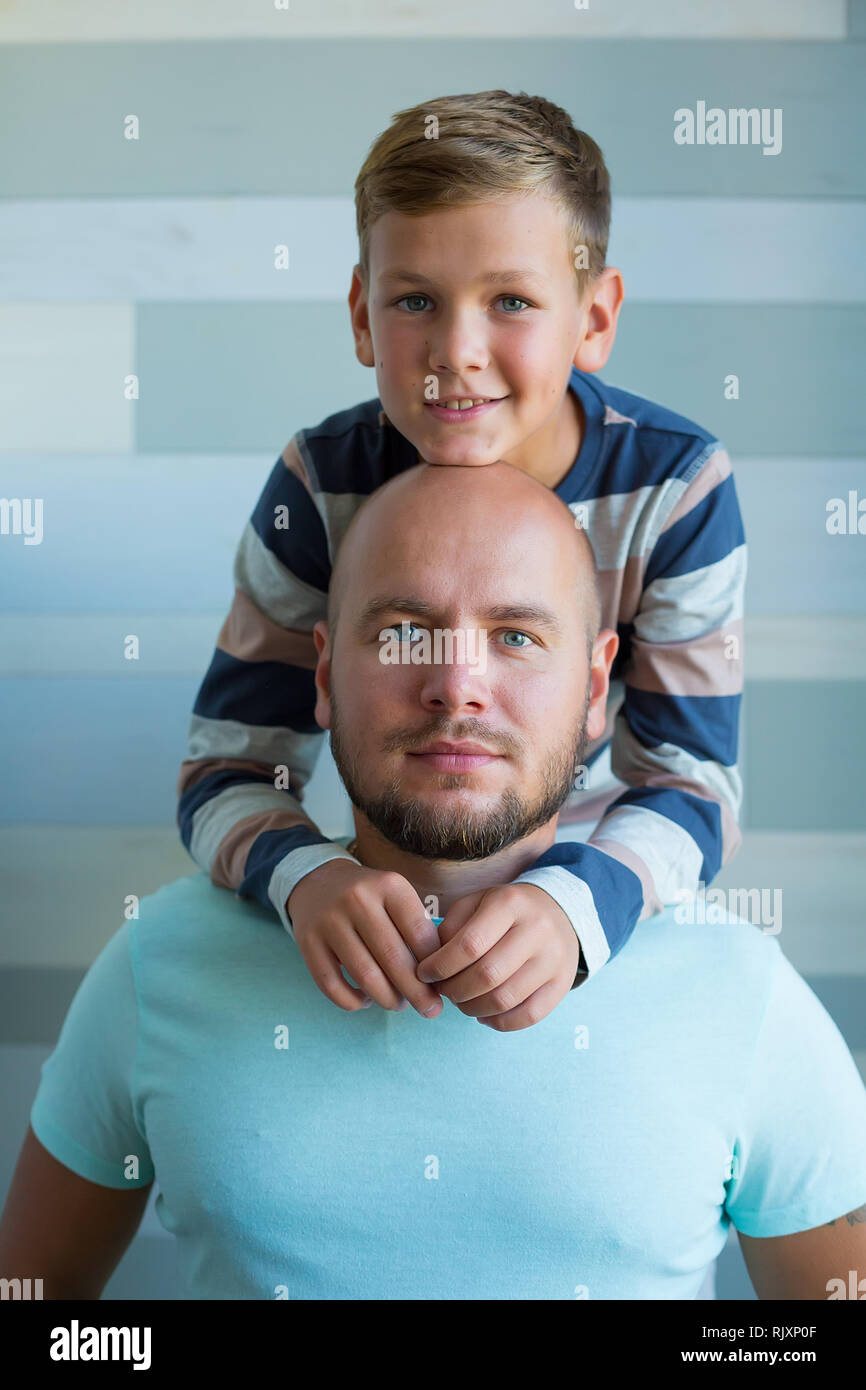 Side view of handsome father and his cute son looking at each other and ...