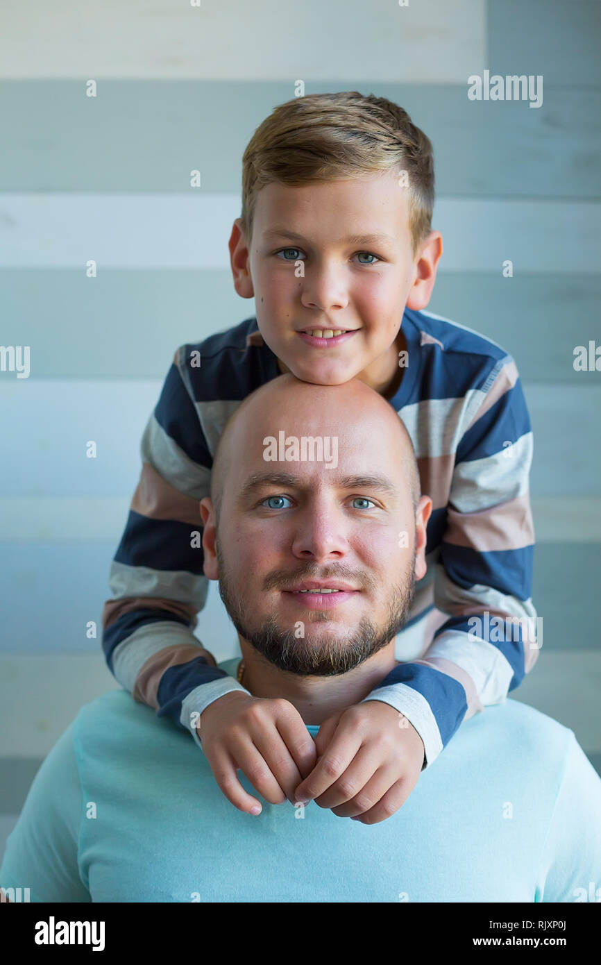 Side view of handsome father and his cute son looking at each other and ...