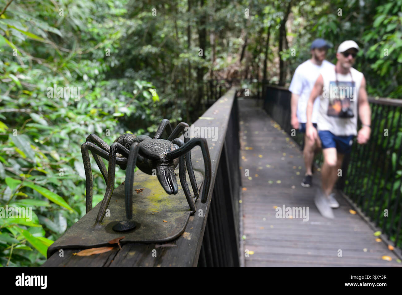 Tourists walking pas an ant sculpture along the boardwalk at Barron ...