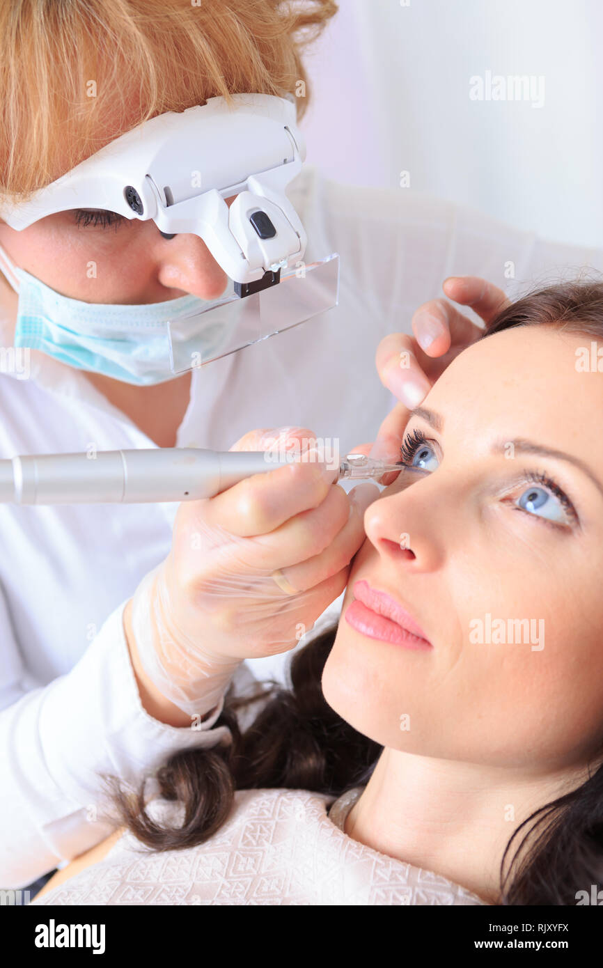 closeup of a female face by receiving of permanent makeup treatment at ...