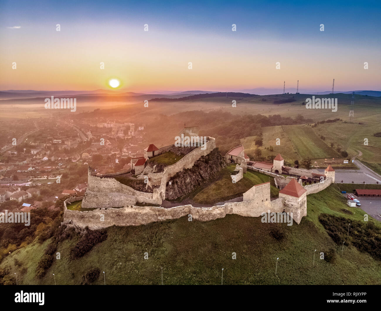 Traditional landscape in Romania with Rupea Fortress and Rupea village ...