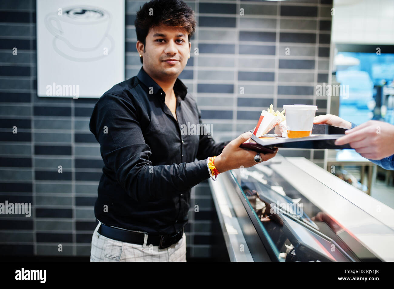 Waiter cashier gives order on food tray to stylish indian man Stock ...