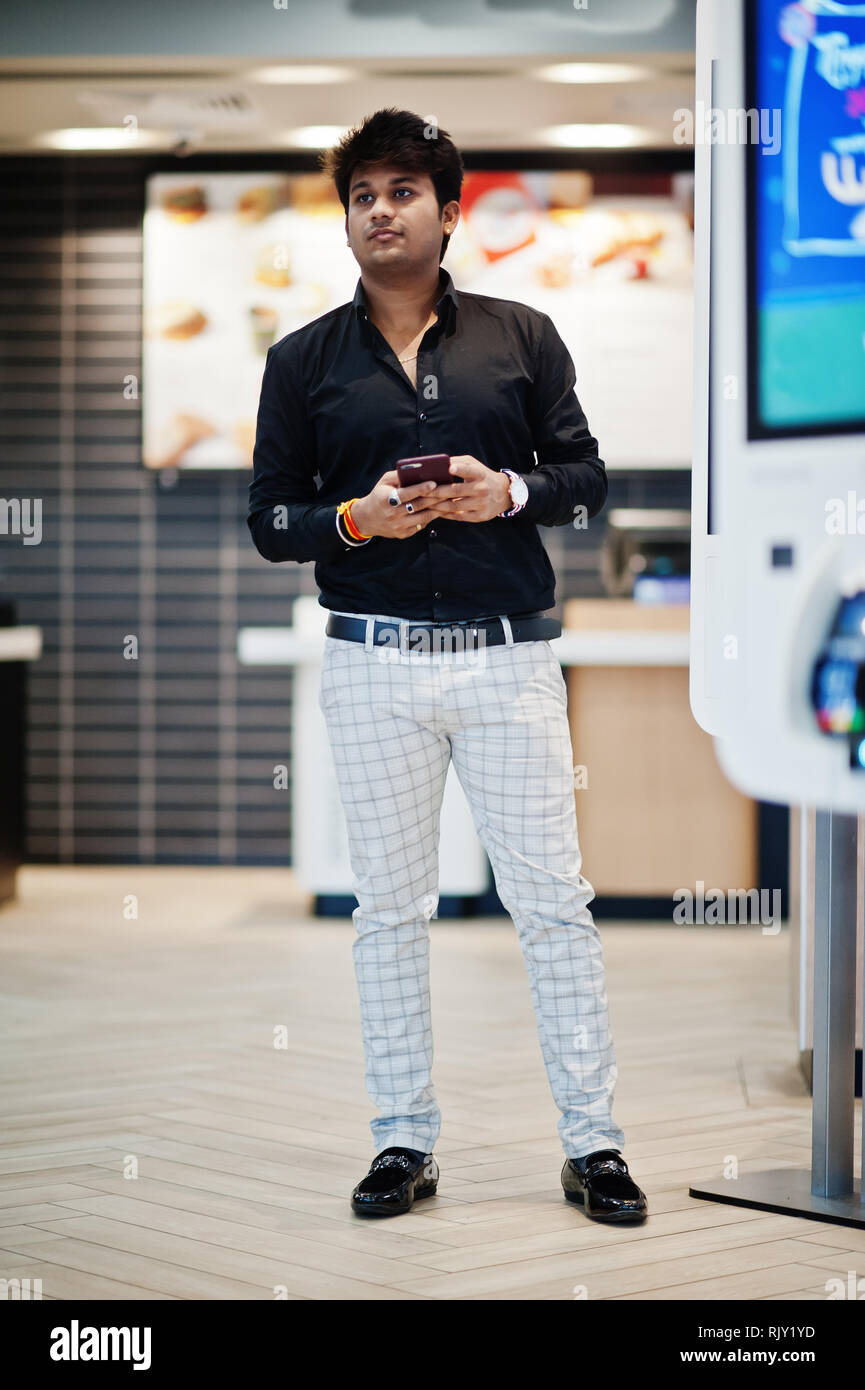 Stylish indian man posed at fast food cafe near self pay floor kiosk ...