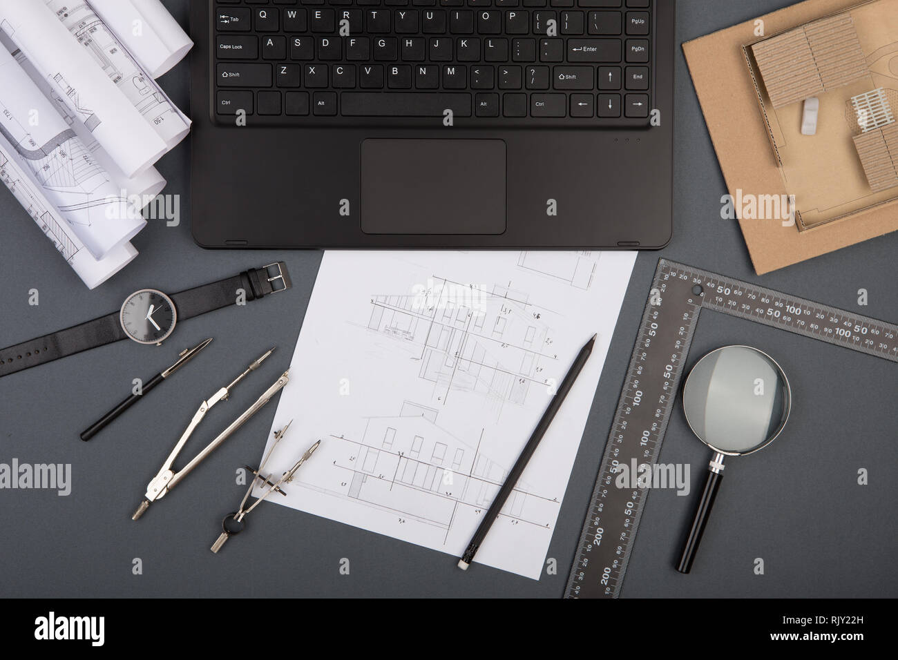 Workplace of architect - construction drawings,laptop, scale model of a ...