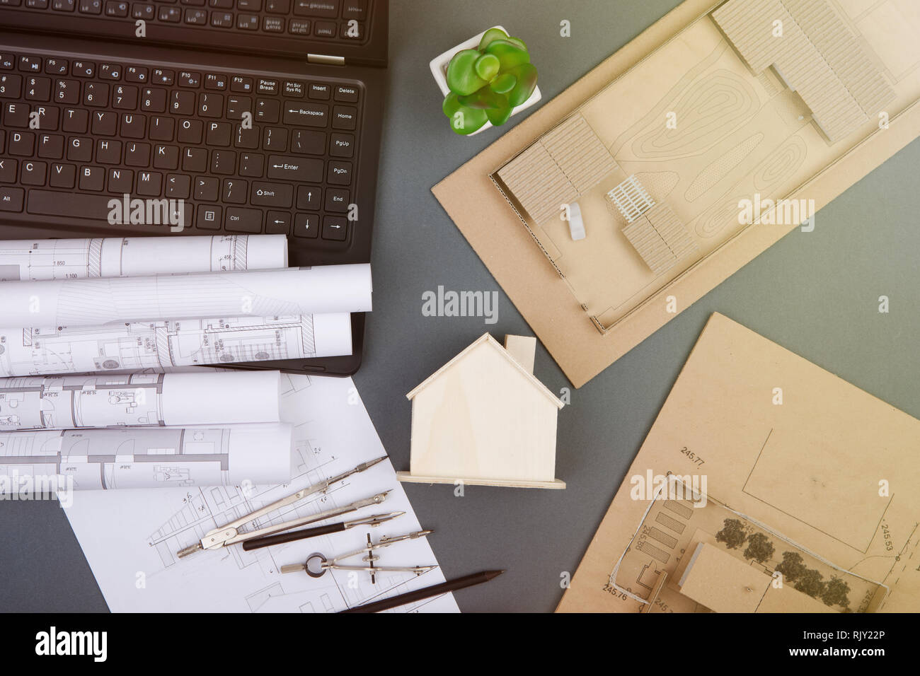 Workplace of architect - construction drawings,laptop, scale model of a ...