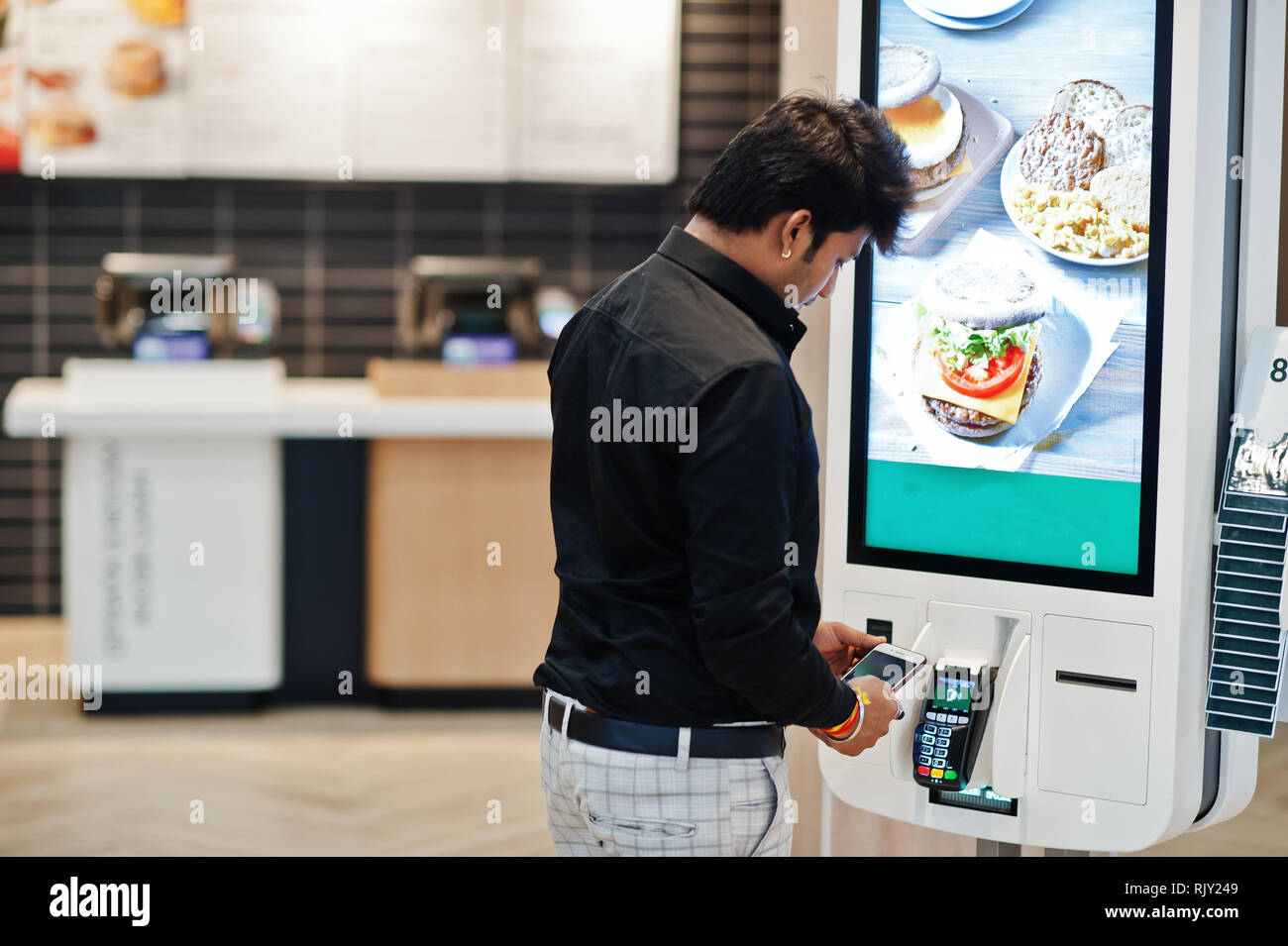 Indian man customer at store place orders and pay by contactless credit ...