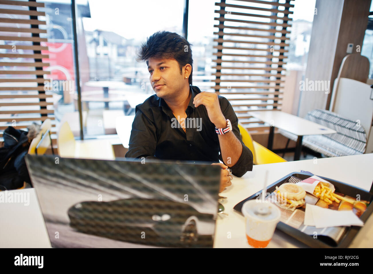 Stylish indian man sitting at fast food cafe against his laptop Stock ...