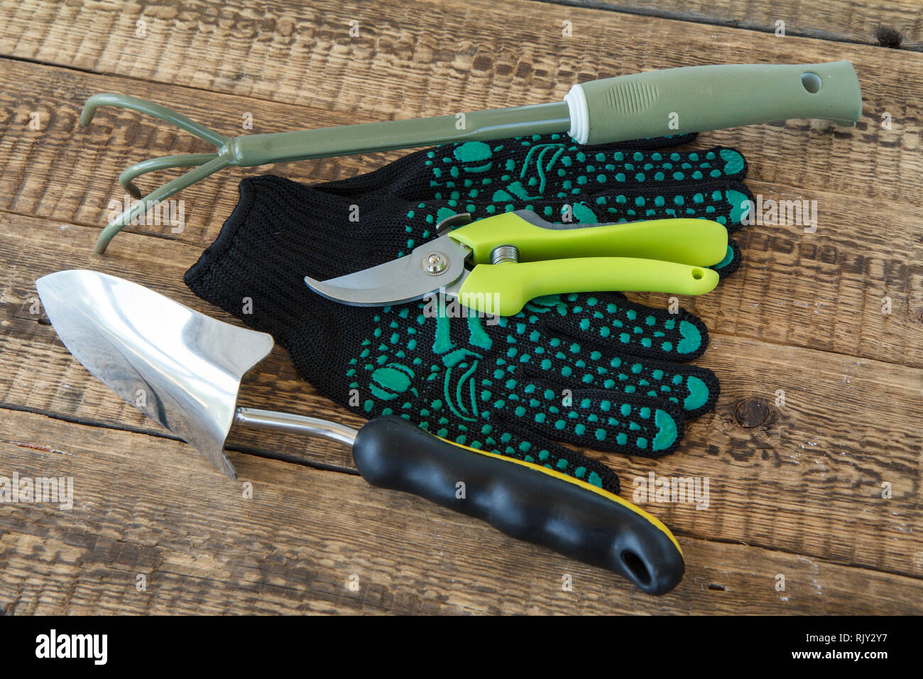 Pair of black garden gloves, small hand garden rake, pruner and trowel ...
