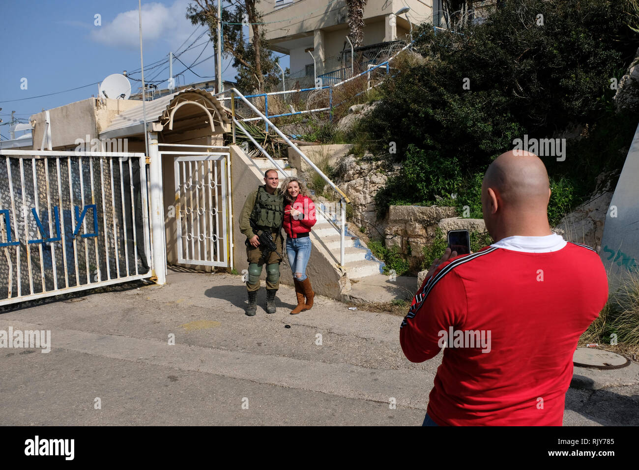 An Israeli civilian posing with an Israeli soldier at the gate of the ...