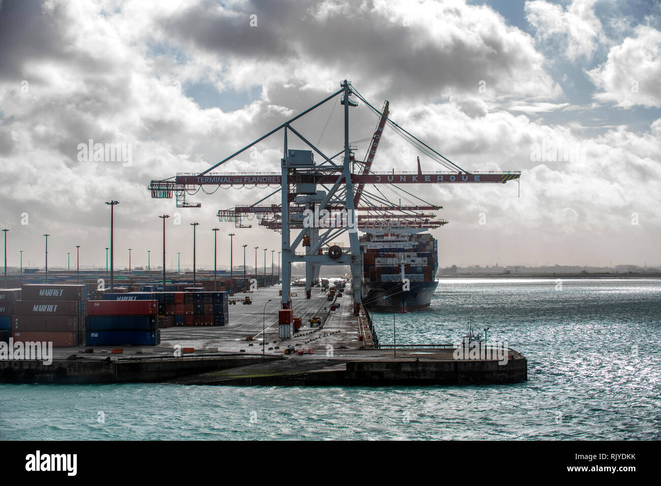 The port of Dunkerque in Northern France. Cranes load container ships ...