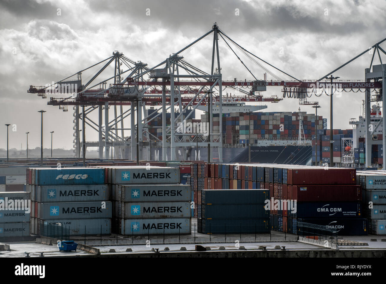 The port of Dunkerque in Northern France. Cranes load container ships ...