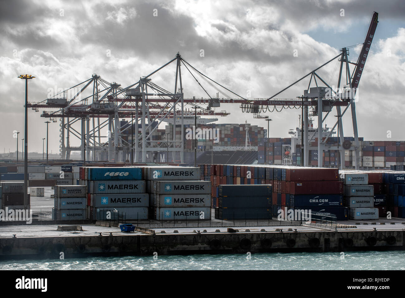 The port of Dunkerque in Northern France. Cranes load container ships ...