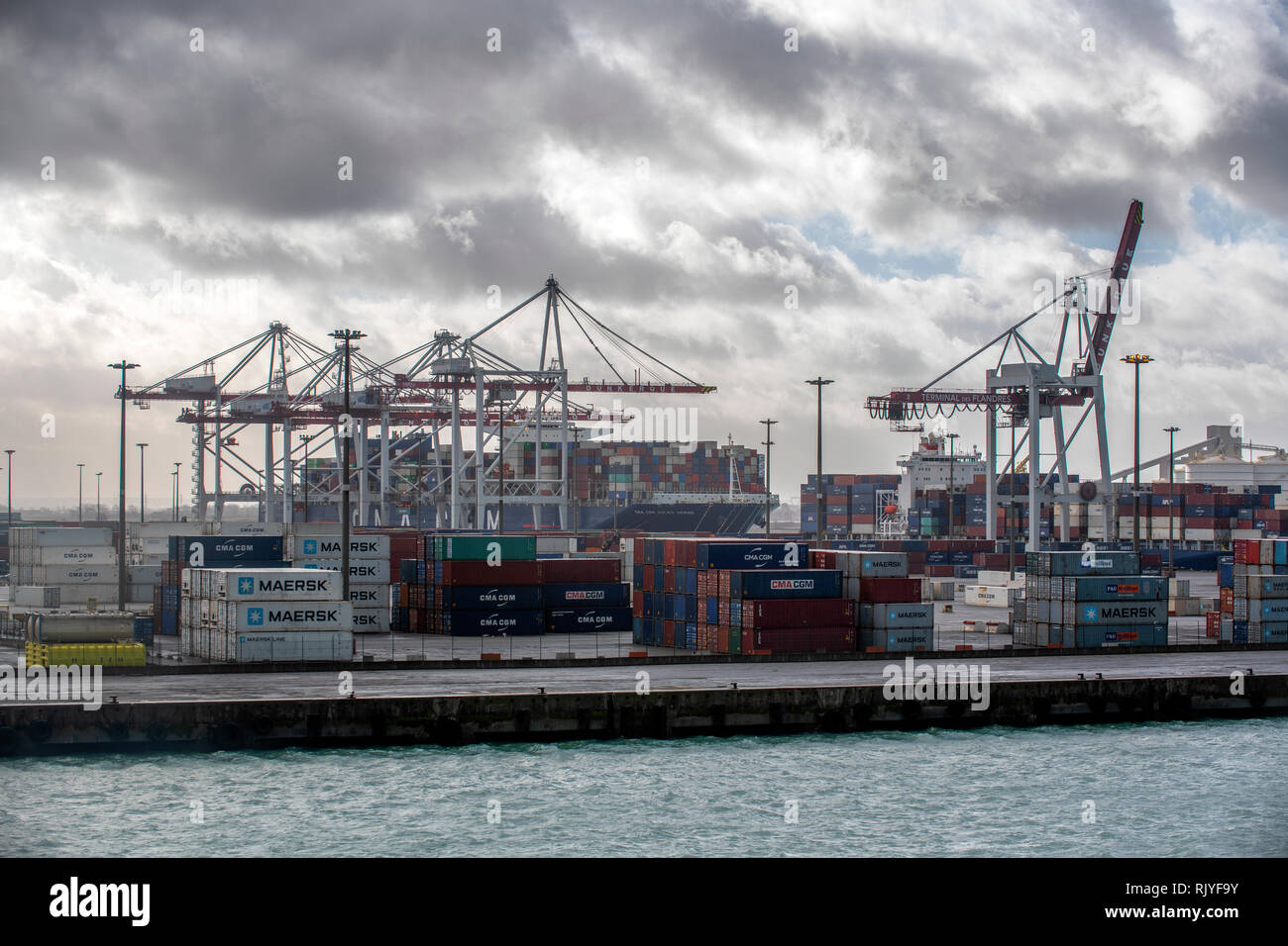 The port of Dunkerque in Northern France. Cranes load container ships ...