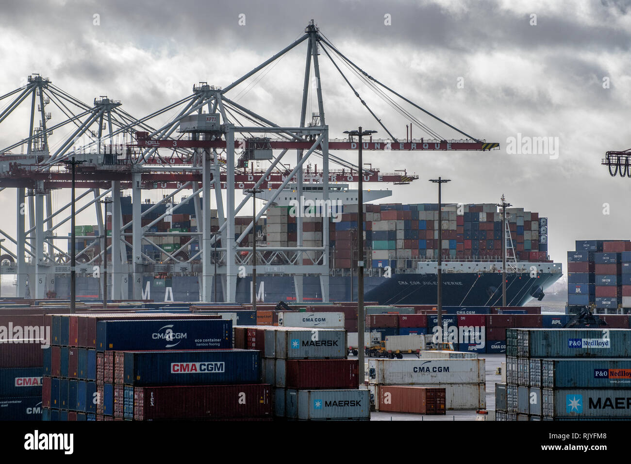 The port of Dunkerque in Northern France. Cranes load container ships ...