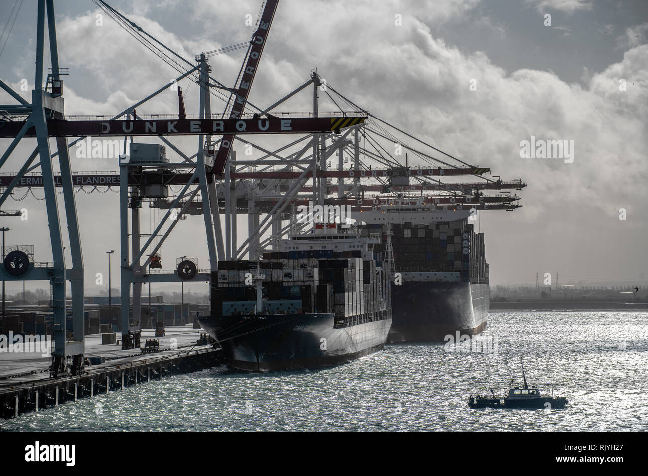 The port of Dunkerque in Northern France. Cranes load container ships ...