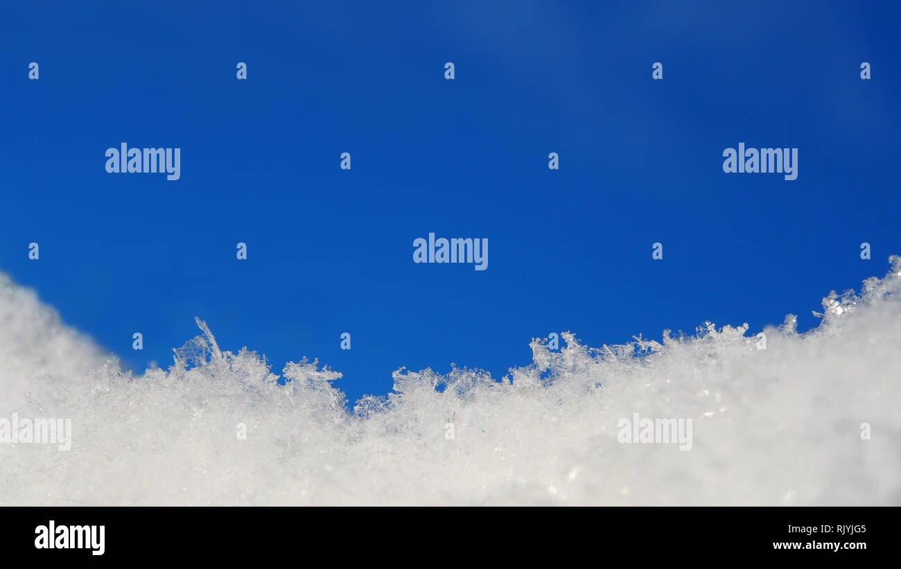 little white snow crystals in front of a blue sky background Stock ...