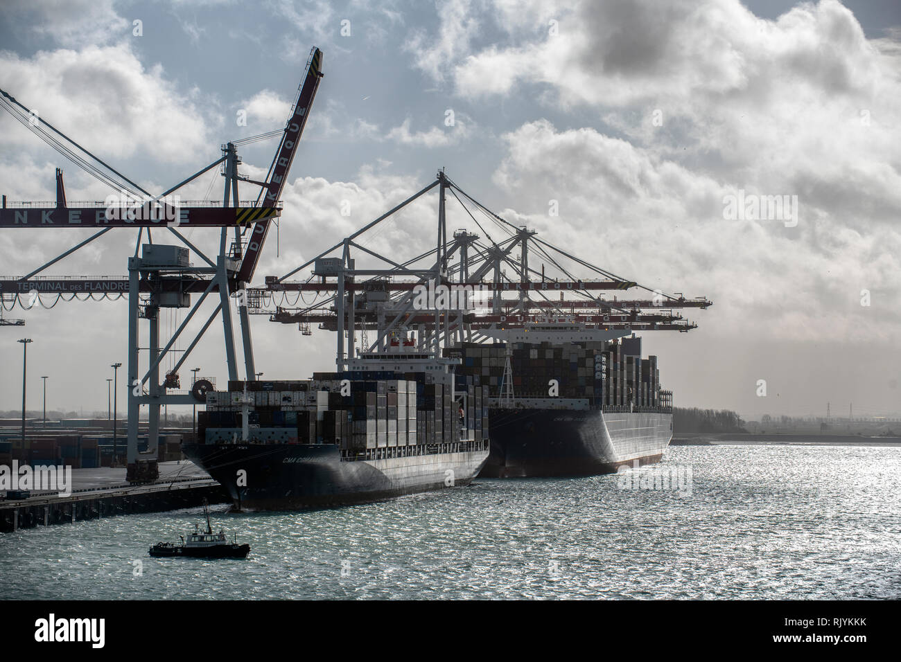 The port of Dunkerque in Northern France. Cranes load container ships ...