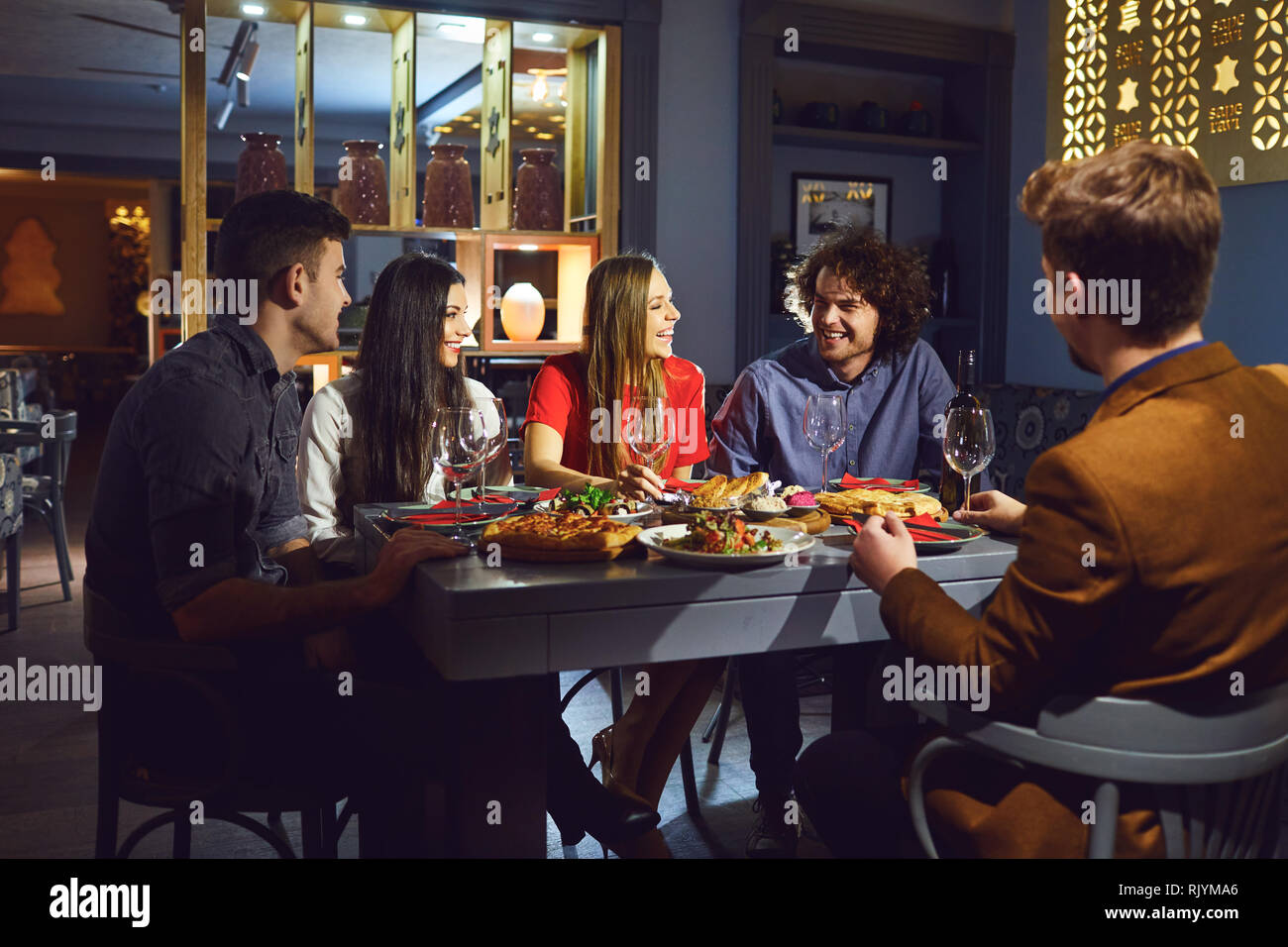 A group of friends laughs in a restaurant at dinner Stock Photo - Alamy