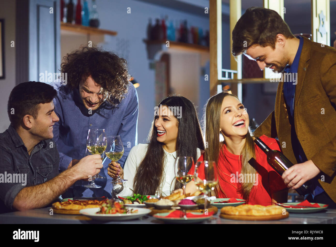 Happy friends talk in a restaurant in the evening Stock Photo - Alamy