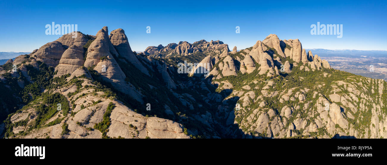 Aerial; drone view of multi-peaked mountain range near Barcelona; sunny ...