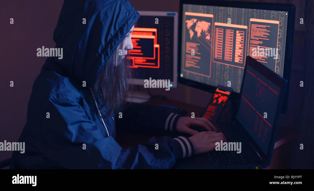Girl Hacker In A Hood Typing Program Code While Committing A Cybercrime