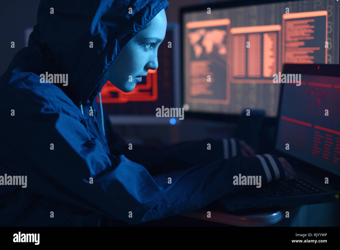 Girl Hacker In A Hood Typing Program Code While Committing A Cybercrime Hacking A System
