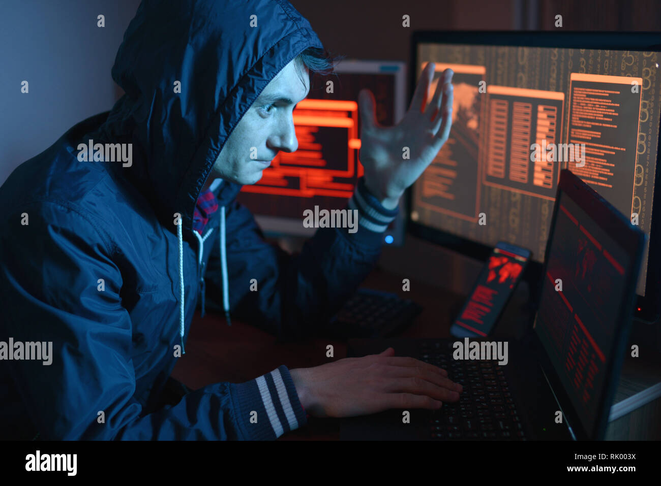 Male hacker celebrates success with a hand gesture. A successful ...
