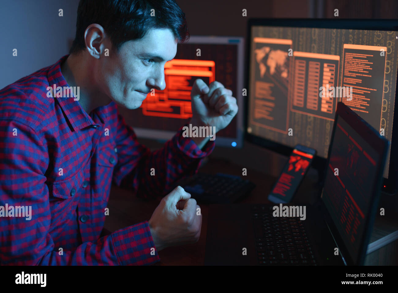Male hacker celebrates success with a hand gesture. A successful ...