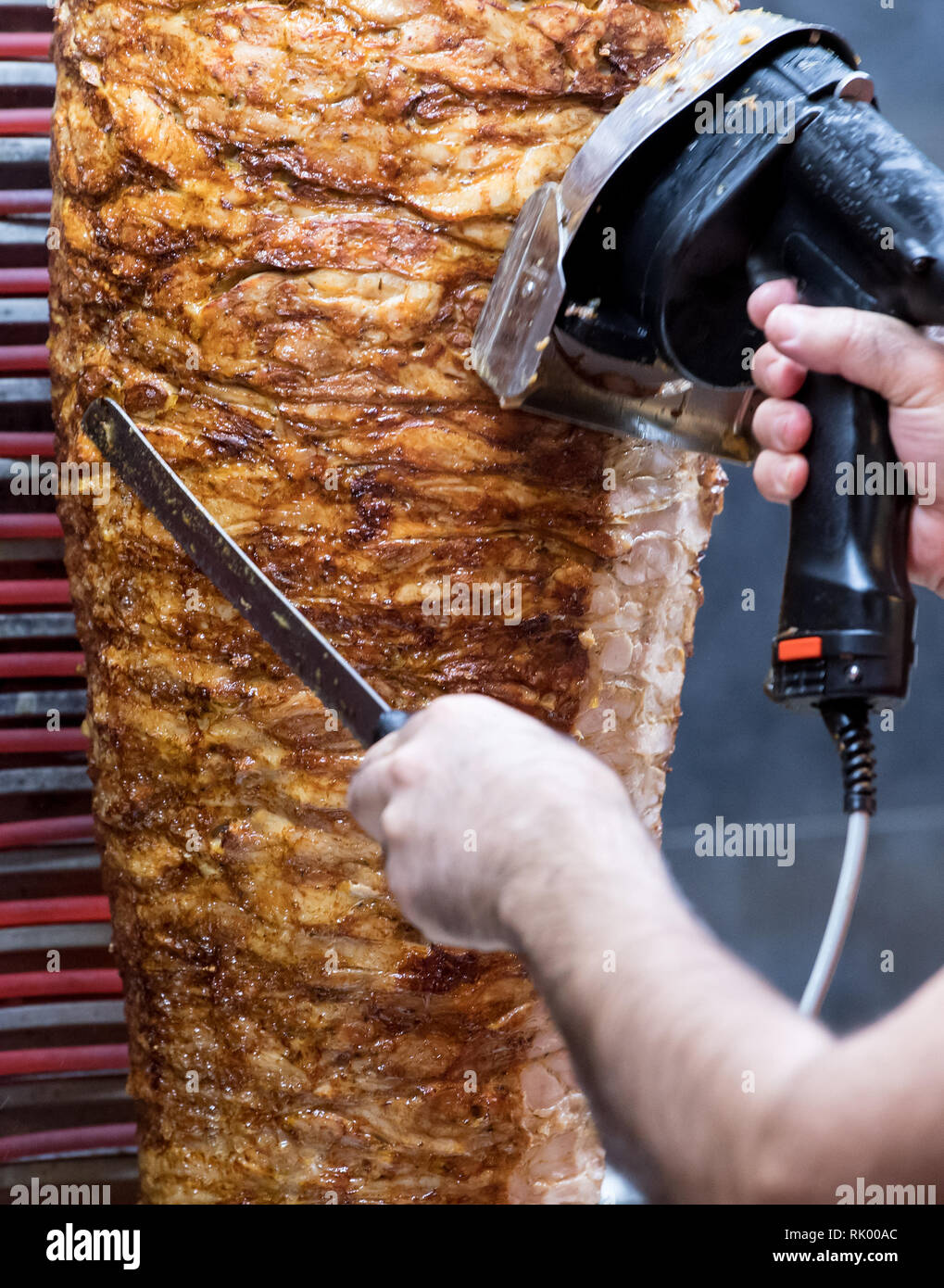 07 February 2019, Bavaria, München: A man cuts meat from a kebab skewer ...