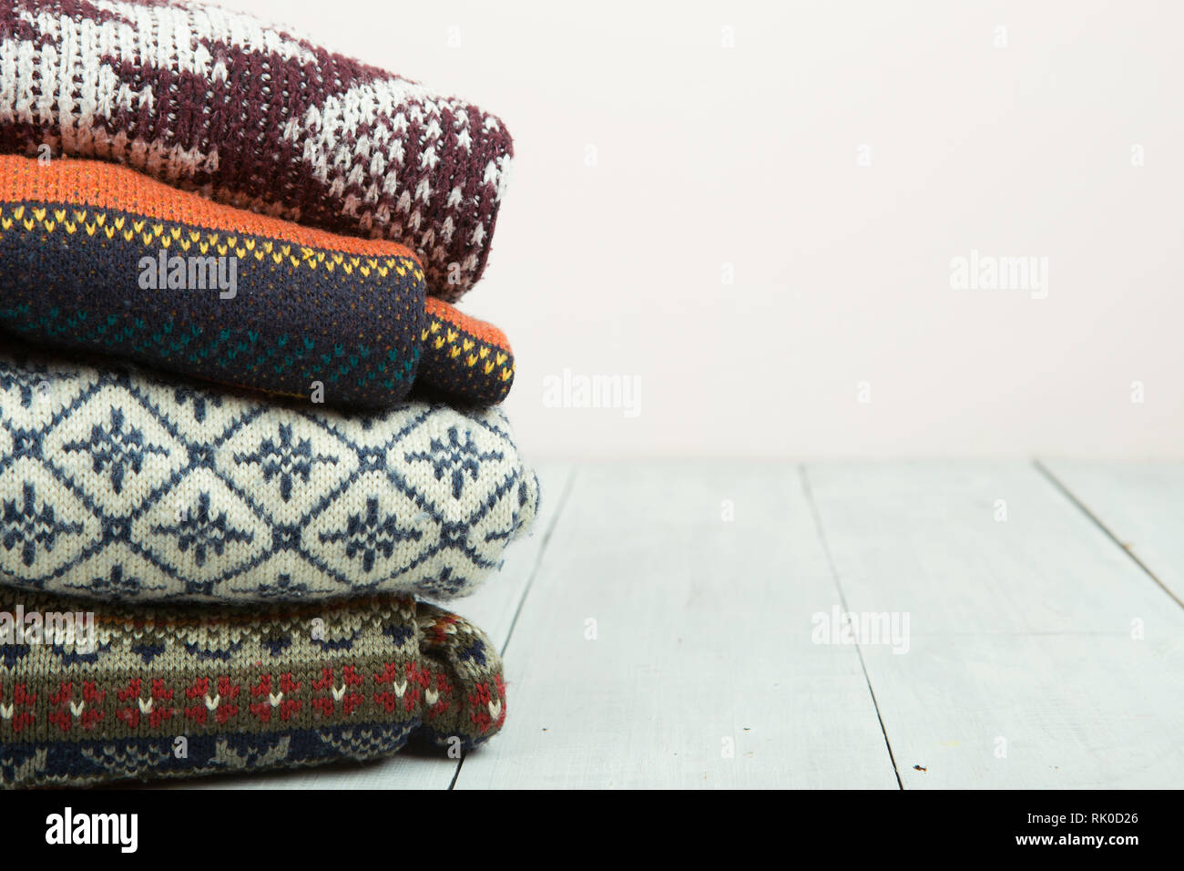 Pile of knitted winter sweaters on wooden background Stock Photo - Alamy