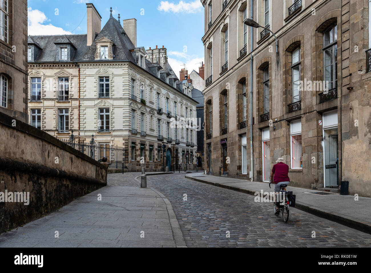 Rennes, France - July 23, 2018: Old man riding a bicycle in old street ...