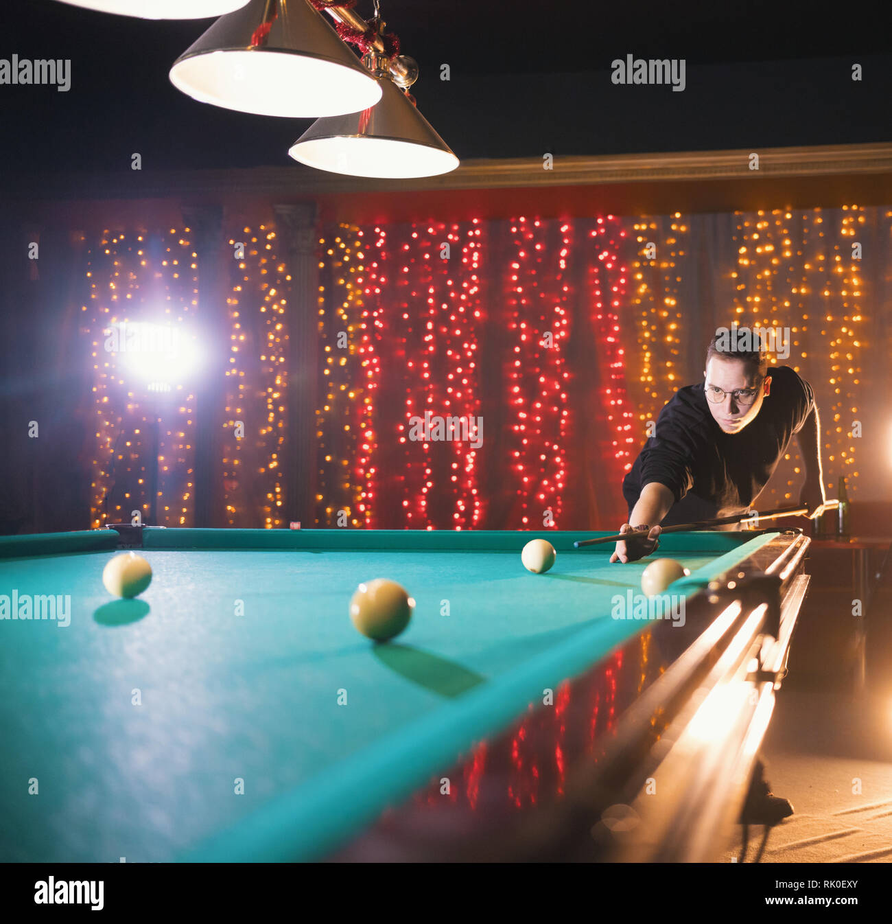 Entertainment concept. Young man in glasses playing billiard Stock ...