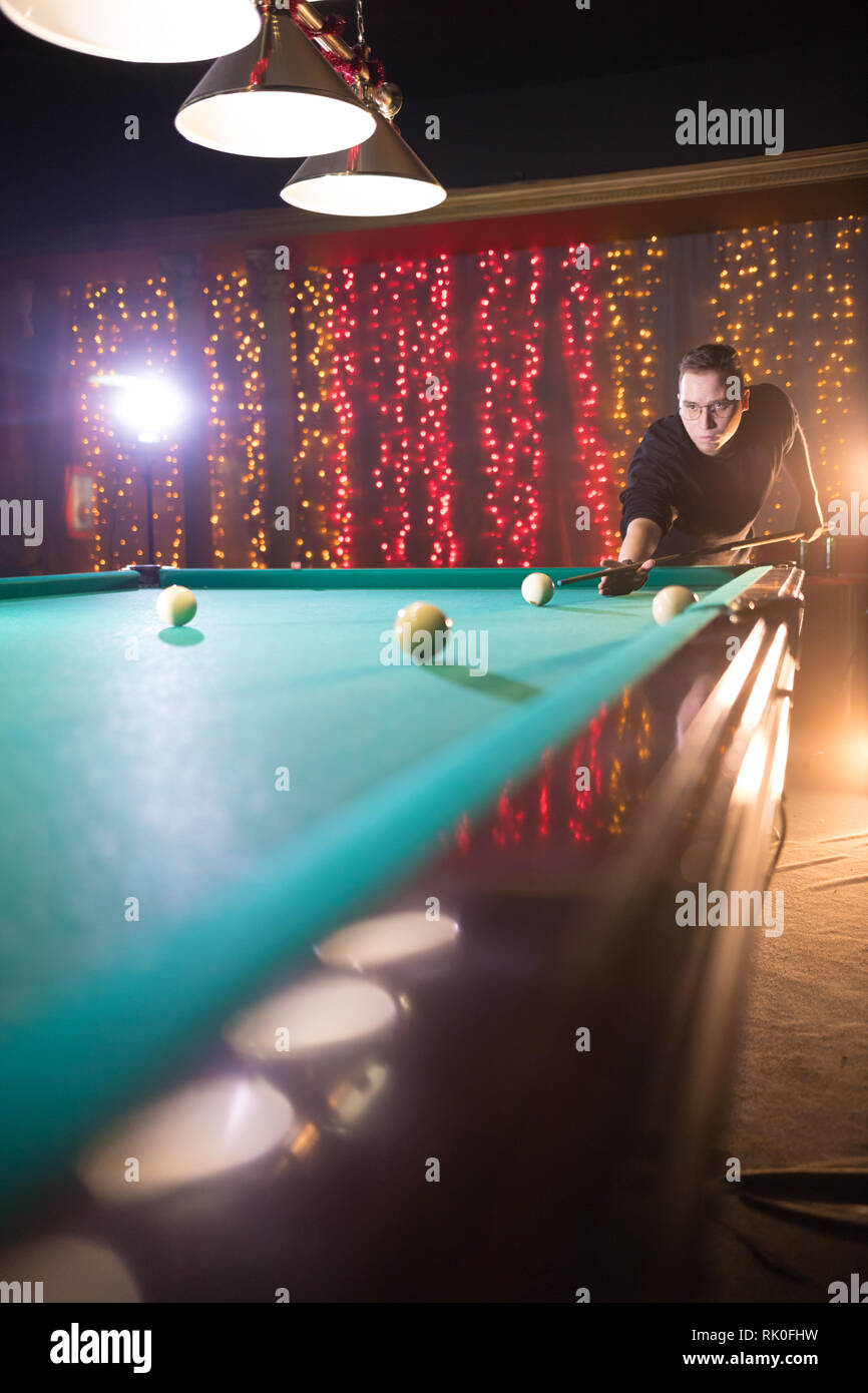 Entertainment concept. Concentrated young man in glasses playing ...