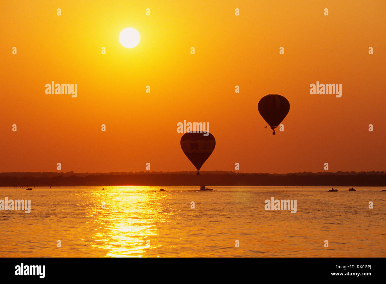 Hot Air Balloons Over Water at Sunset Stock Photo - Alamy