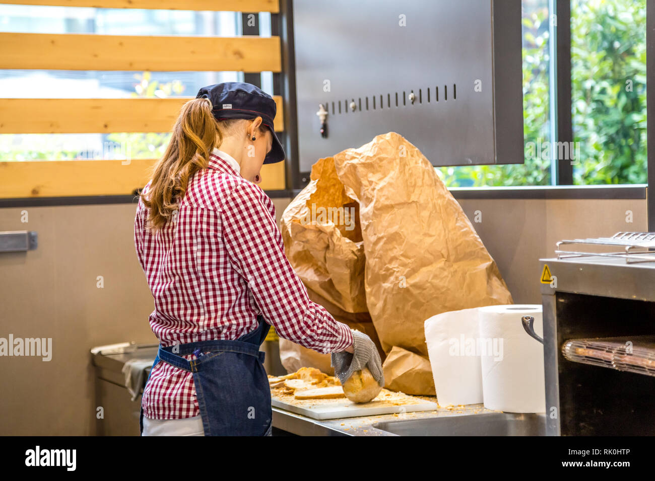 BOLOGNA, ITALY - DECEMBER 16, 2018: baker cutting bread at FICO Eataly ...