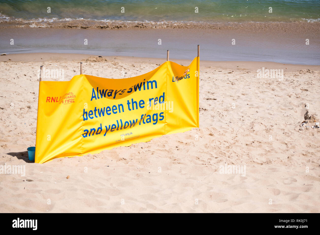 RNLI yellow beach safety sign showing safe areas for swimming placed on ...