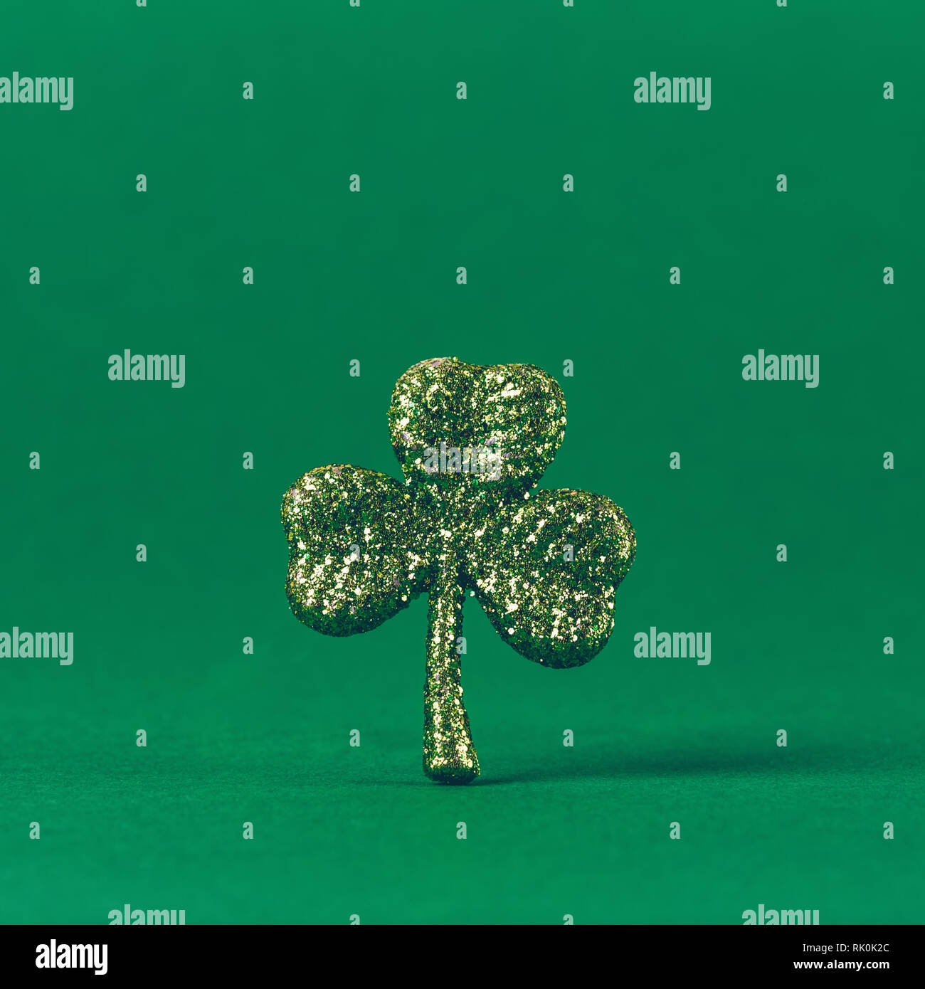 Glitter shamrock on green paper background. St Patricks day symbol ...